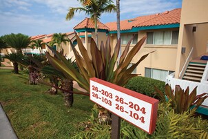 Um hotel com uma placa indicando os números dos quartos 26-203, 26-204, 26-103 e 26-104.
