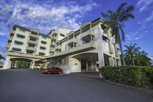 Um hotel de vários andares com design arquitetônico moderno, apresentando varandas e uma entrada coberta.