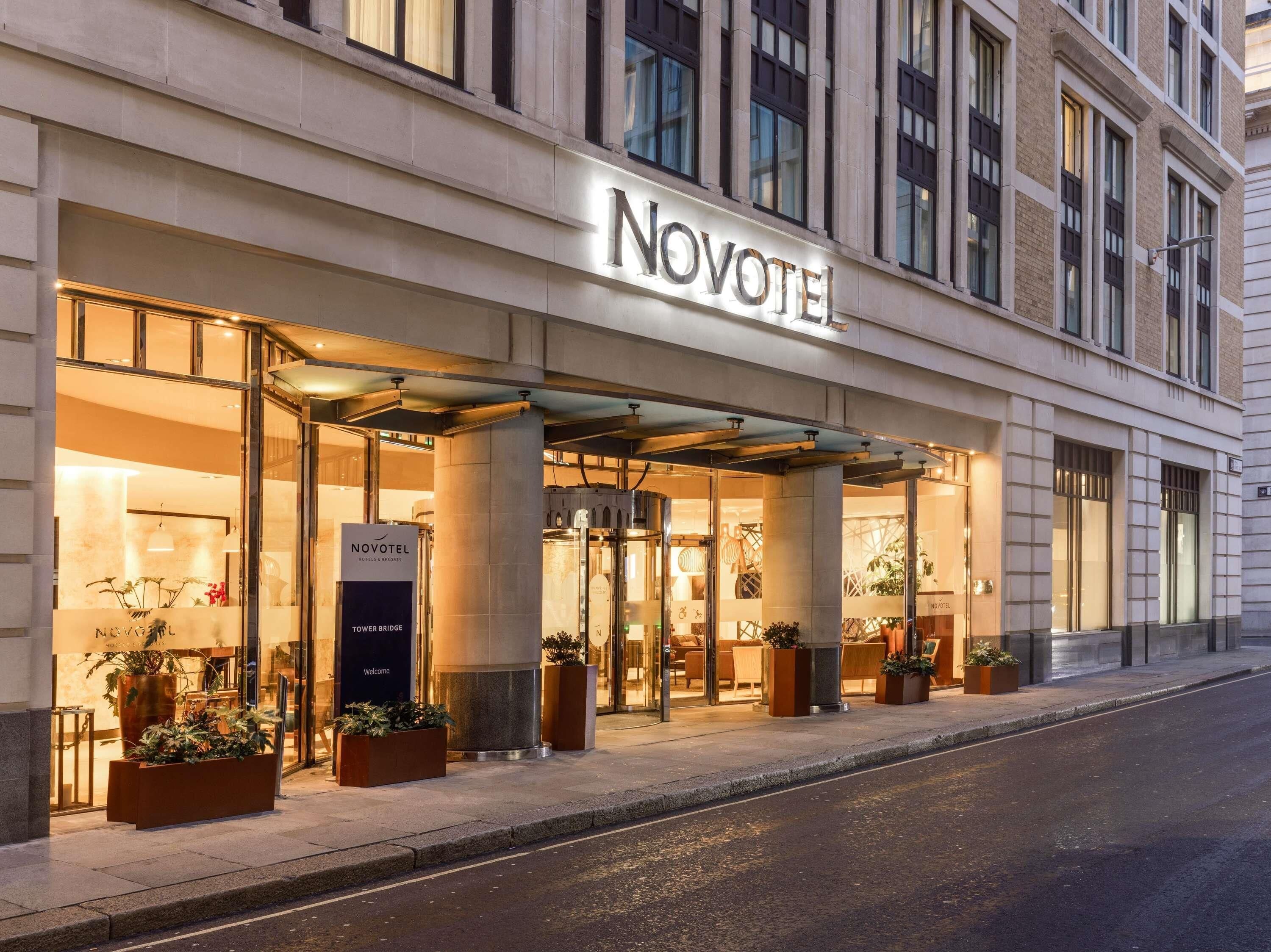 Exterior do hotel Novotel Tower Bridge, com fachada moderna, grandes janelas e uma entrada convidativa.