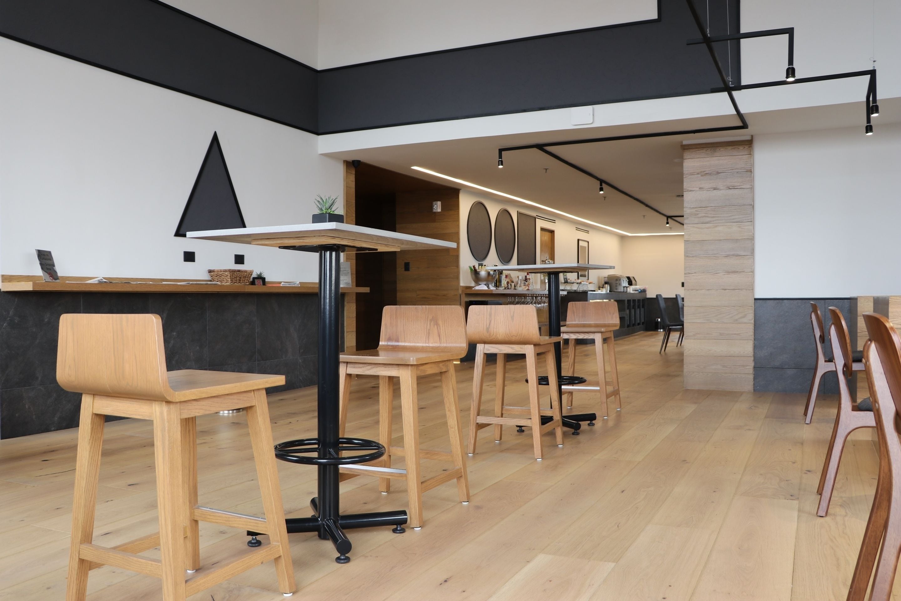 Interior moderno com banquetas de madeira, balcão de recepção e design limpo e minimalista.