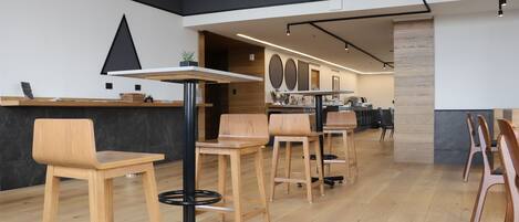 Interior moderno com banquetas de madeira, balcão de recepção e design limpo e minimalista.