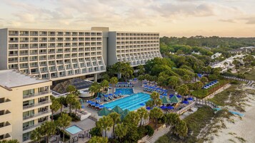 Um hotel com vários andares, piscina e área de praia.