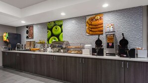 Uma cozinha moderna com bancada, diversos eletrodomésticos e produtos alimentícios em exposição.