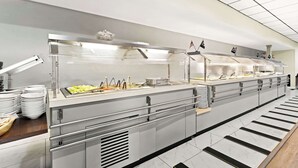 Disposição de buffet com diversas estações de serviço, bandejas e utensílios.