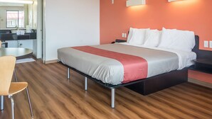Quarto de hotel moderno com uma cama, uma escrivaninha e uma cadeira.