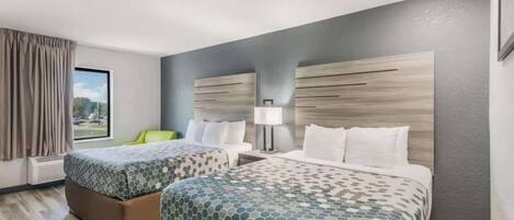 Quarto de hotel com duas camas, janela com cortinas, vista para o exterior e design moderno com parede cinza e cabeceira de madeira.