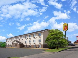 Um hotel Super 8 com fachada de tijolos, várias janelas e estacionamento.