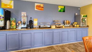 Uma mesa de pequeno-almoço com diversos alimentos e uma máquina de café.