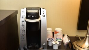Máquina de café Keurig com suporte para cápsulas e algumas cápsulas de café.