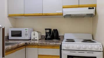 Uma cozinha equipada com micro-ondas, torradeira, cafeteira e fogão.