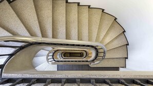 Escada em espiral com corrimão de metal e núcleo central.