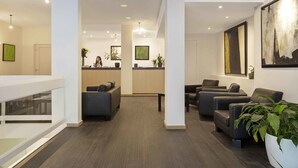 Um lobby moderno com balcão de recepção, área de estar e escada.