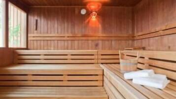 Uma sauna de madeira com bancos e um assento de bancada.