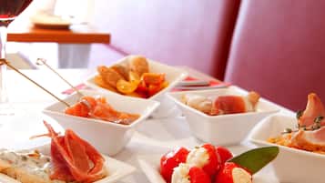 Uma mesa com diversos alimentos, incluindo pão, tomates e queijo.