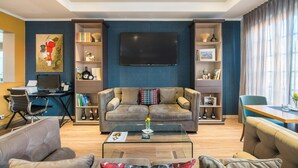 Uma sala de estar moderna com sofá, mesa de centro e televisão de tela plana na parede.