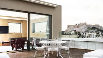 Terraço moderno no telhado com área de refeições, vista para um centro histórico e uma janela grande.