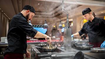 Uma cozinha profissional com chefs preparando alimentos.