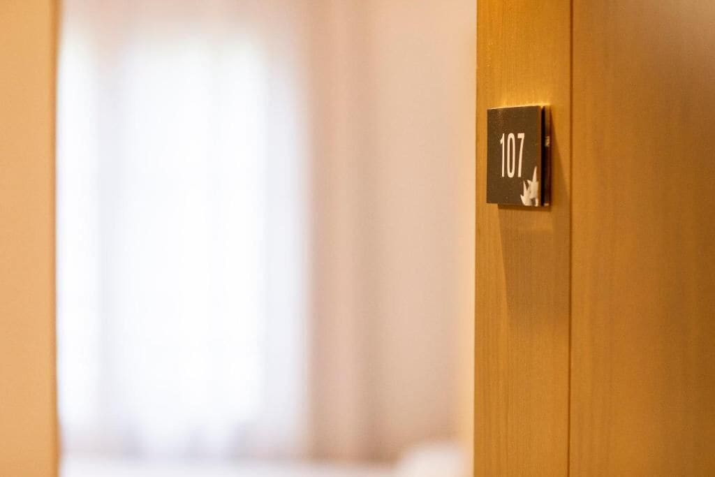 Porta de quarto de hotel com uma placa indicando o número 107.