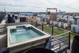 Piscina no terraço com vista para a paisagem urbana, incluindo uma ponte e edifícios residenciais.