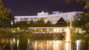 Um hotel com uma grande placa indicando "CENTARA HAE SOT HILL RESORT" e um elemento decorativo com água na frente.