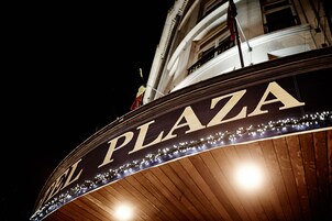 Uma placa com a palavra 'PLAZA', rodeada por luzes de corda.