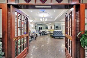 Um lobby com um candelabro, área de estar e um letreiro com a inscrição "ROYAL ALBERT".