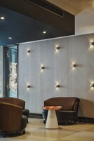 Um interior moderno com área de estar, parede com iluminação embutida e vista para área externa.