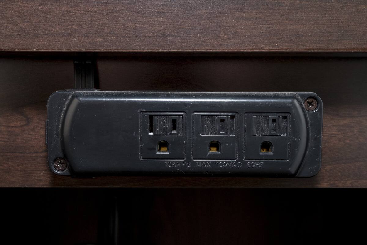 Tira-cabos com três tomadas, uma porta USB e etiqueta indicando frequência de 60Hz.