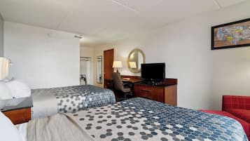 Quarto de hotel com duas camas, uma escrivaninha com televisão, uma cadeira, um espelho e um mapa na parede.