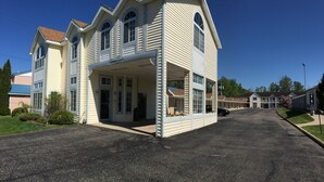 Um edifício de dois andares com varanda coberta e garagem.