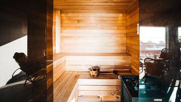 Uma sala de sauna com bancos de madeira, um balde e um aquecedor de sauna Harvia.