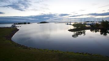 Um lago tranquilo com barcos, um cais e uma área gramada.
