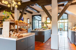 Uma cozinha com ilha central, vigas de madeira e vista para o exterior.