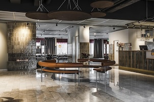 Um hall moderno com área de estar central, lareira e bar.