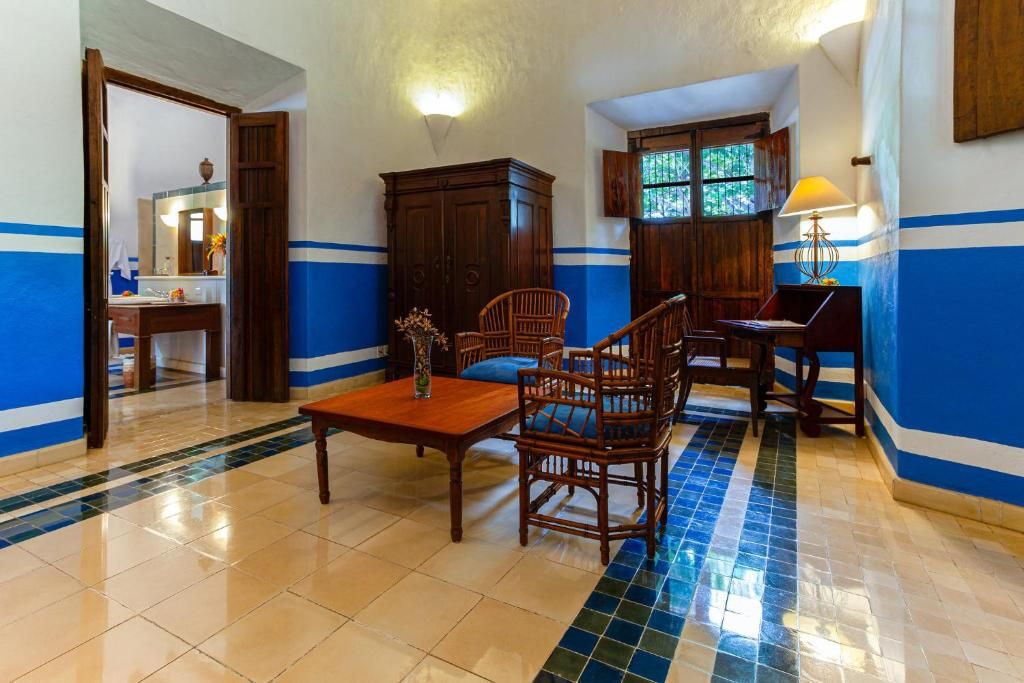 Quarto com mesa de jantar de madeira, duas cadeiras de vime, um armário e janela com vista.