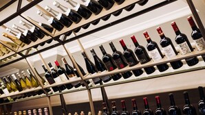 Uma estante com várias garrafas de vinho.