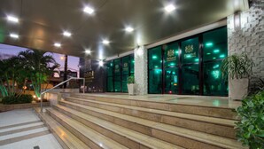 Entrada de hotel com uma escadaria que leva a uma área de recepção.