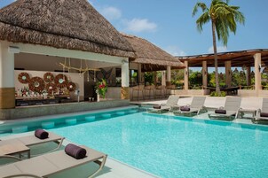 Uma área de piscina com espreguiçadeiras e um bar.
