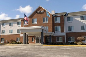 Um hotel Fairfield by Marriott com fachada de tijolos, entrada coberta e uma bandeira.