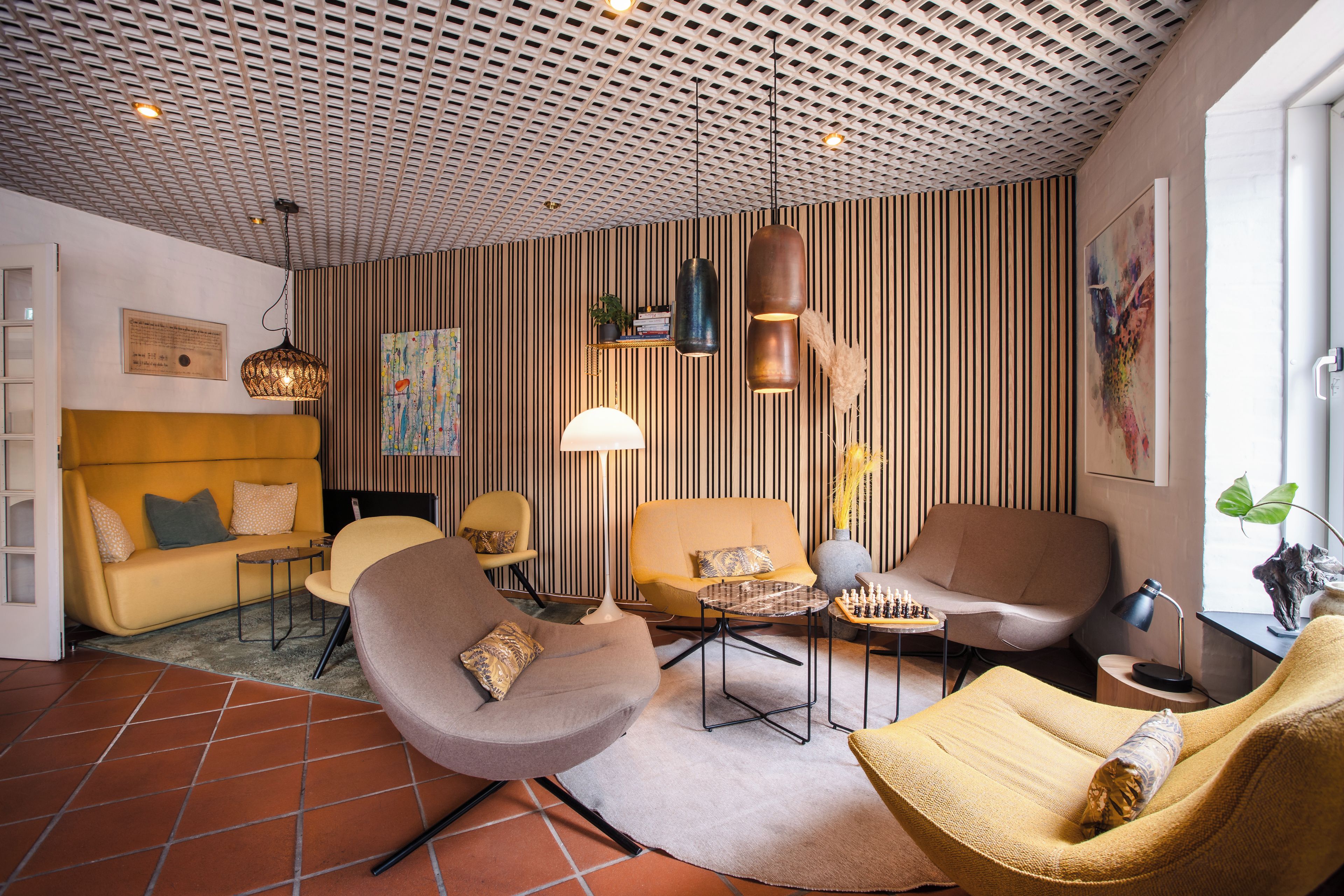 Uma sala de estar moderna com teto estampado, um sofá, poltronas, uma mesa de centro e um tabuleiro de xadrez.