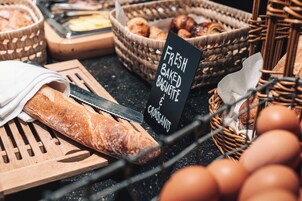 Vitrine de padaria com baguetes e croissants fresquinhos.