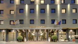 Um hotel com fachada moderna, várias janelas e uma entrada destacada com toldo.