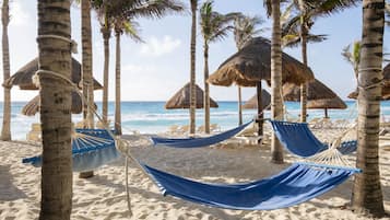 Na praia, praia de areia branca, toldos de praia (sobretaxa)