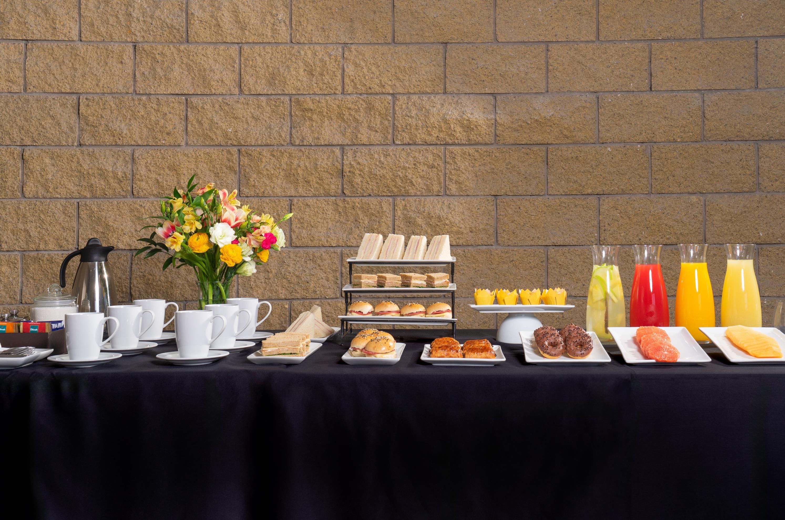 Um buffet de café da manhã com diversos alimentos e bebidas.