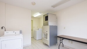 Uma lavanderia equipada com máquina de lavar Whirlpool, secadora e aquecedor de água.