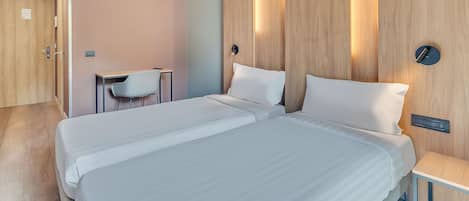 Quarto de hotel moderno com uma cama grande, uma escrivaninha e uma cadeira.