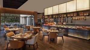 Um restaurante moderno com área de bar, piso de madeira e vista para o exterior.