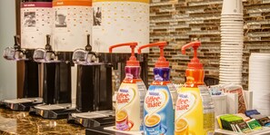 Uma estação de café com vários dosadores e garrafas de Nestle Coffee-Mate em diferentes sabores.