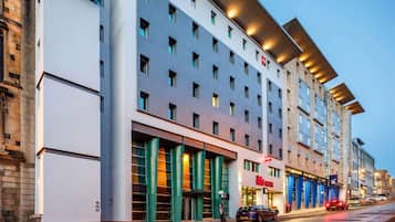Um hotel moderno com fachada plana, diversas janelas e entrada destacada.