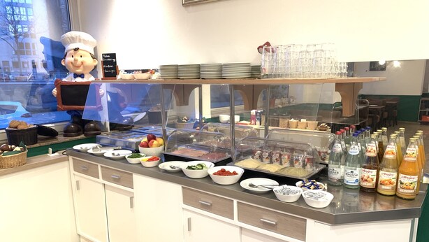 Uma mesa de buffet com diversos alimentos e bebidas.